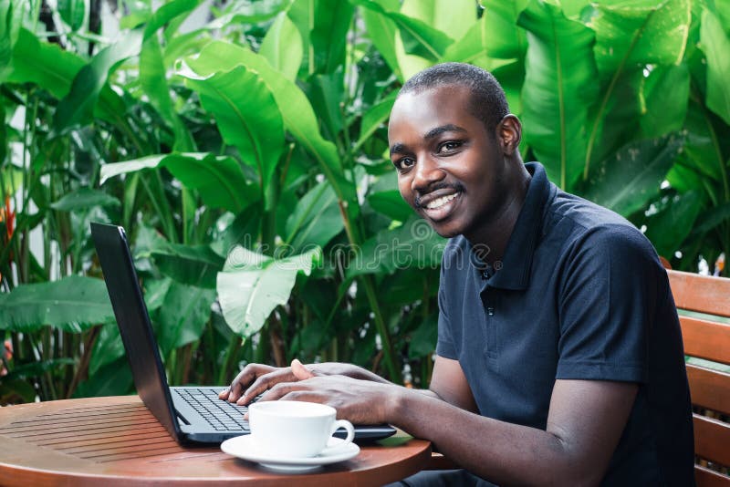 African Man Using a Laptop Computer Outside a Coffee Cafe Stock Photo ...