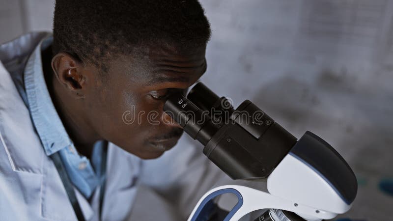 African Man Using Microscope in Laboratory Setting, Portraying Science ...