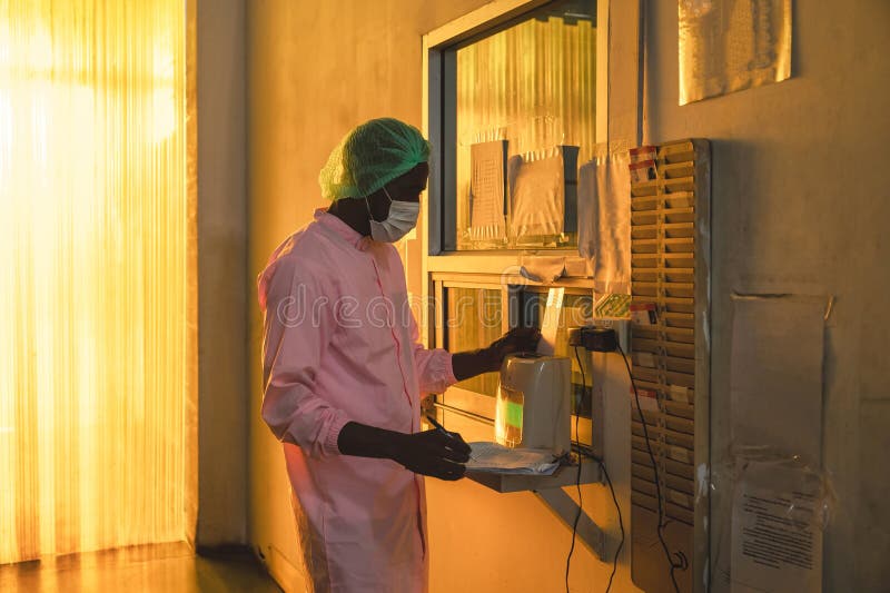 African Quality Control Employee Man in Sterile Suit Clock in with Time ...