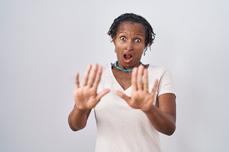 African Woman with Dreadlocks Standing Over White Background Afraid and ...