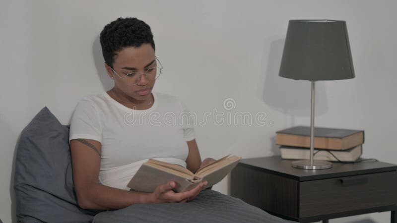 African Woman Reading Book while Sitting in Bed Stock Image - Image of ...