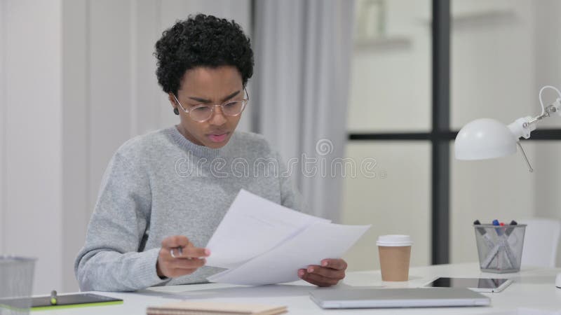 African Woman Reading Papers at Work Stock Photo - Image of busy ...
