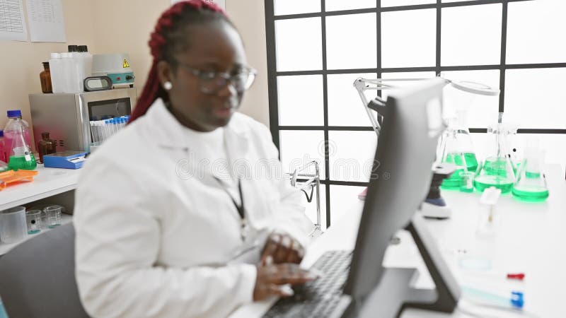 African Woman Scientist with Braids Typing on Computer in Bright ...