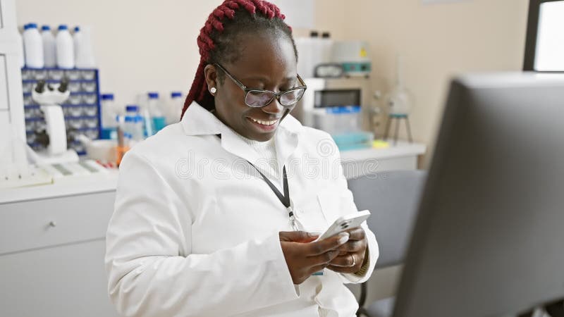 African Woman Scientist with Braids Using Smartphone in Laboratory ...