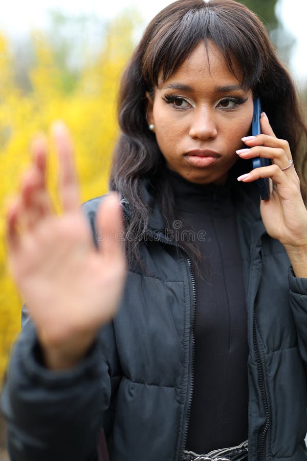 African Woman Talking On Mobile Phone And Showing Stop Gesture Stock
