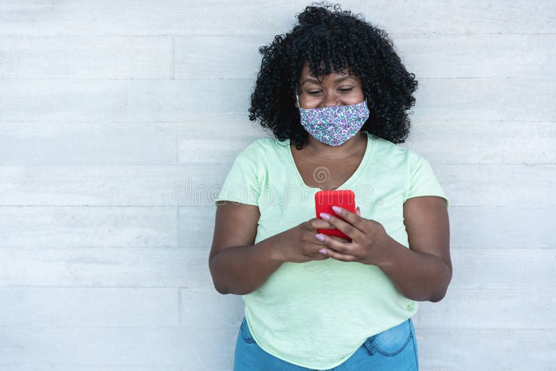African Woman Using Mobile Phone while Wearing Protective Face Mask ...