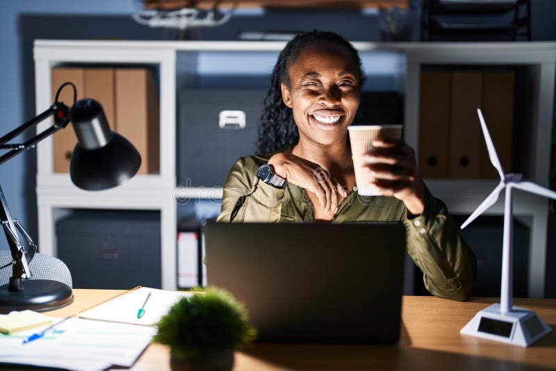 African Woman Working Using Computer Laptop at Night Winking Looking at ...