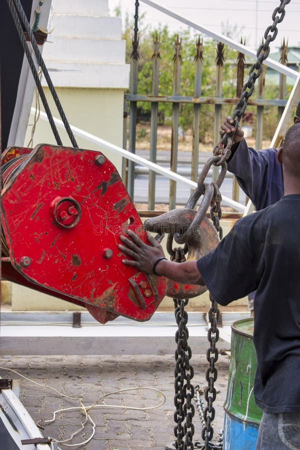 African Worker Securing a Crane Hook Stock Photo - Image of mechanical ...