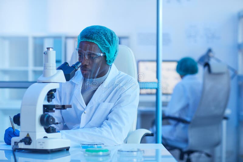 African Doctor Examining with Microscope Stock Photo - Image of looking ...