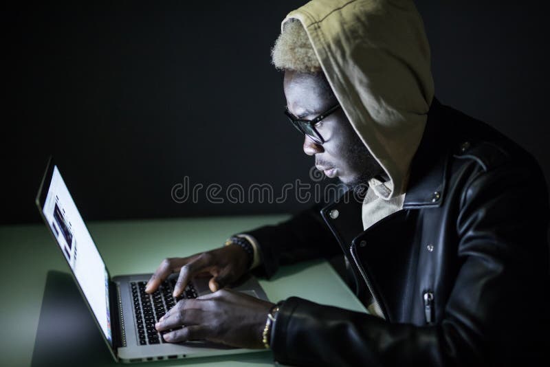 Afro American Hacker in Hood Using Laptop Computer in the Dark Hack ...