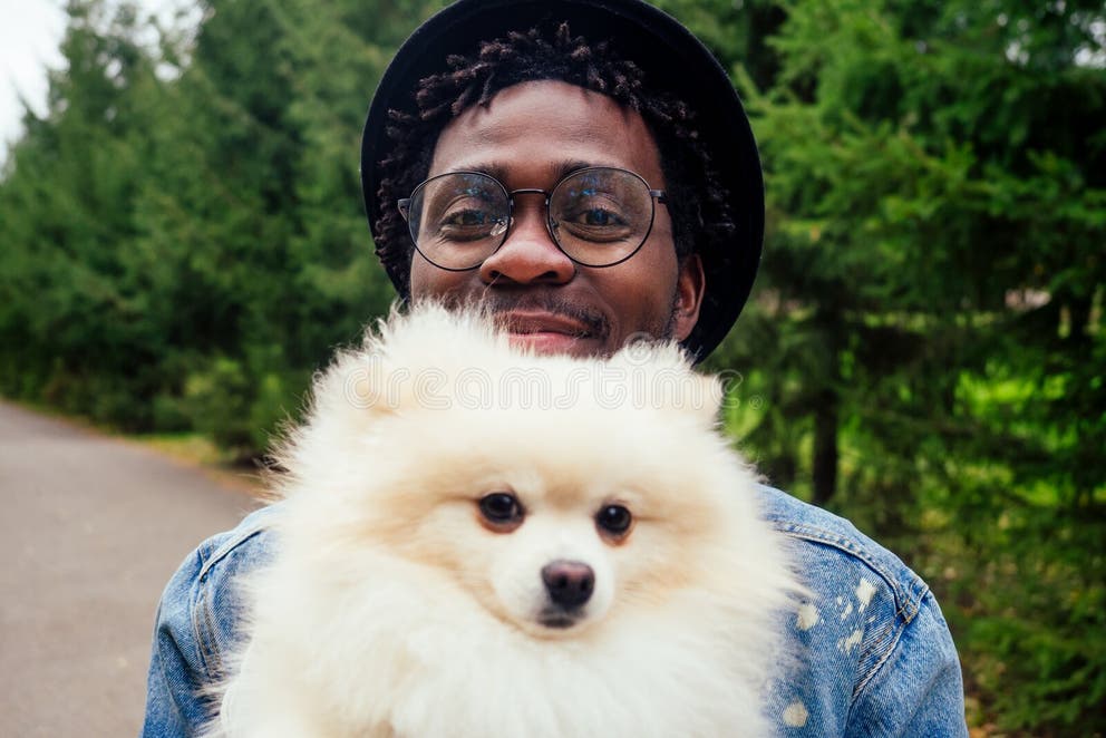 Afro Man Hugging His Fluffy Spitz in Park Stock Image - Image of ...
