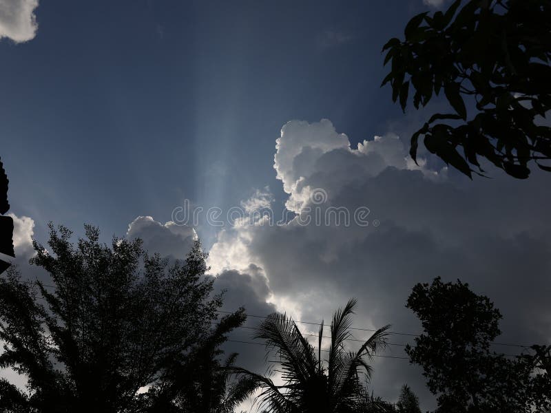 Afternoon Sun Rays Behind the Clouds on a Blue Sky Background Stock ...