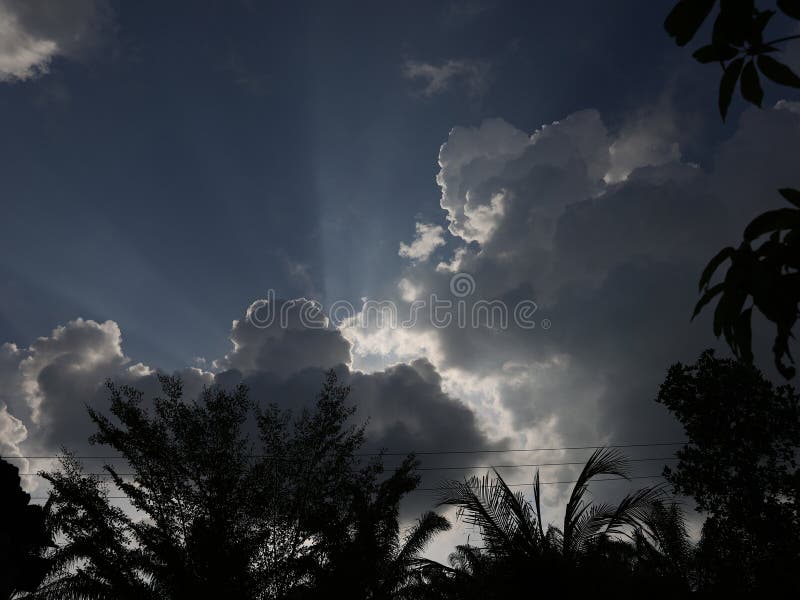 Afternoon Sun Rays Behind the Clouds on a Blue Sky Background Stock ...