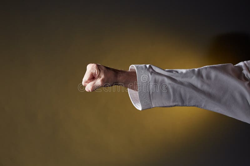 Against a Dark Yellow Background, Punch and Block Hand in Karategi ...