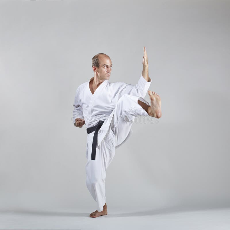 Against a Gray Background, an Active Athlete Performs Formal Karate ...