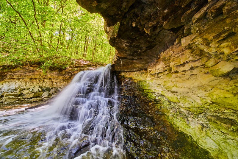 Against Rocky Cliff with Large Waterfall Over Rocks Stock Photo - Image ...