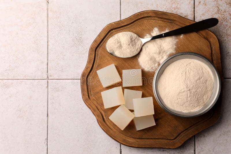 Agar-agar Jelly Cubes and Powder on Tiled Surface, Top View. Space for ...