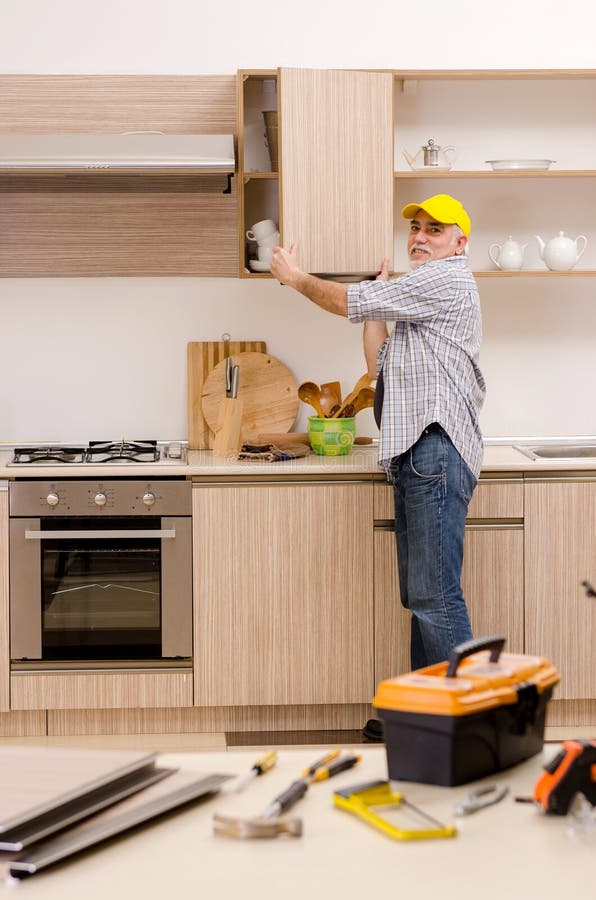 The Aged Contractor Repairman Working in the Kitchen Stock Photo ...
