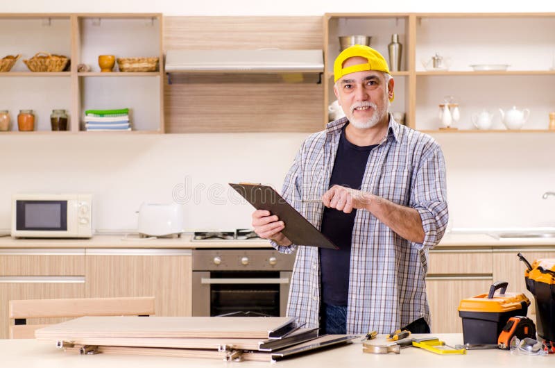 The Aged Contractor Repairman Working in the Kitchen Stock Photo ...