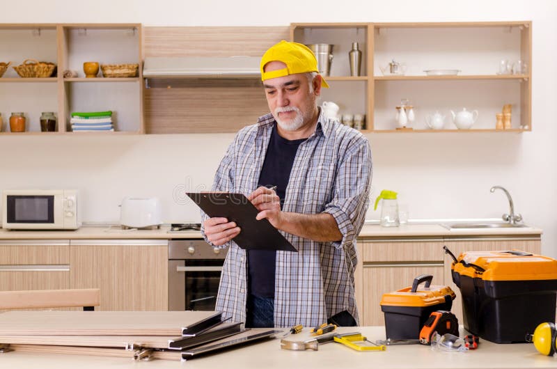 The Aged Contractor Repairman Working in the Kitchen Stock Photo ...