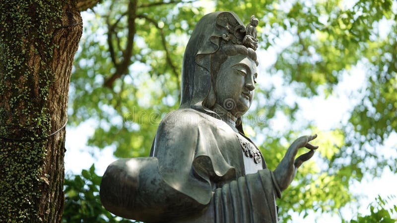 Aged Hindu Goddess Devi Statue Stands on a Lush Green Backdrop of Trees ...
