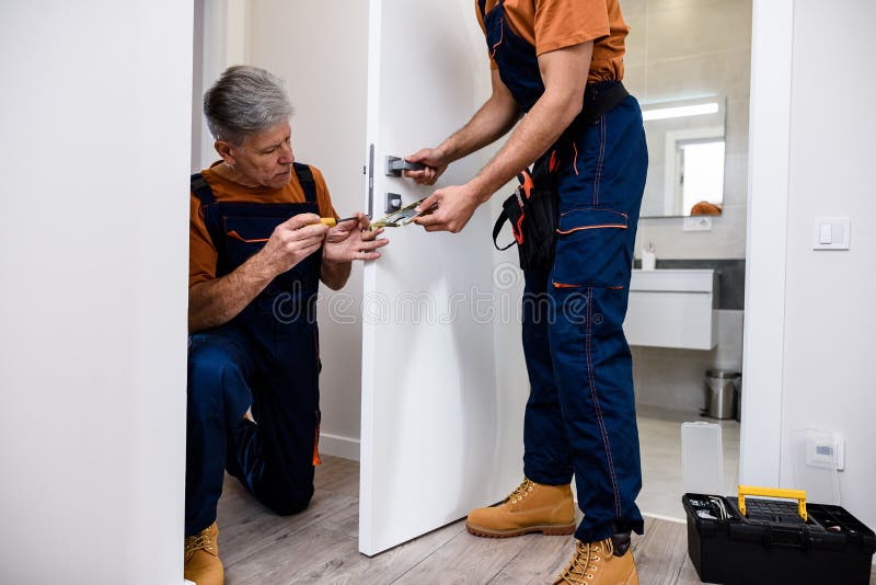Aged Locksmith, Repairman, Worker in Uniform Installing, Working with ...