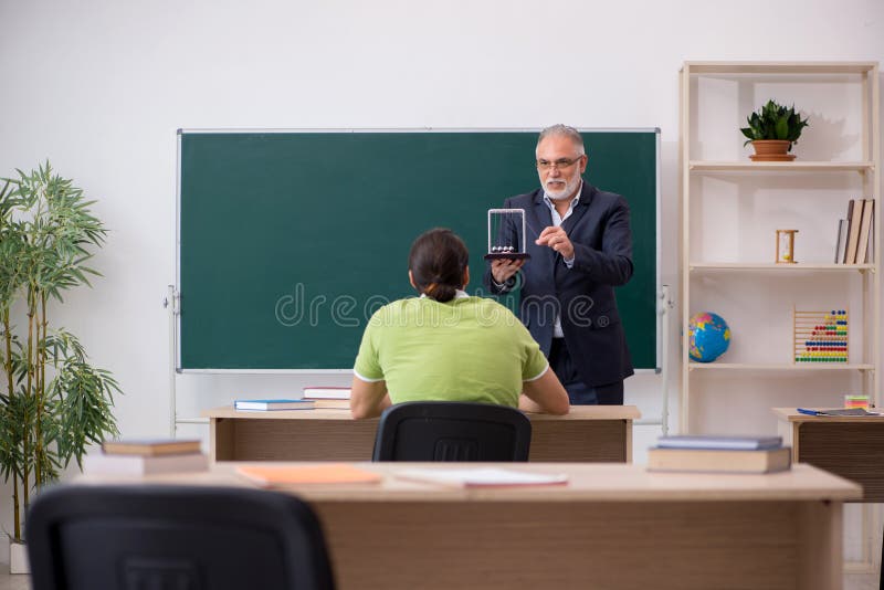 Aged Physics Teacher and Male Student in the Classroom Stock Image ...