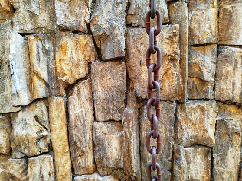 Aged Stone Wall with a Rusty Chain Hanging Vertically. Stock Image ...