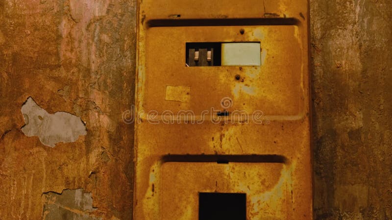 Aged Yellow Electrical Box with Visible Rust Mounted on a Cracked Wall ...