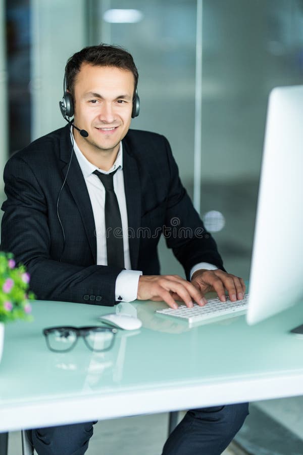 Agent with Headset Smiling while Working on His Computer Stock Image ...