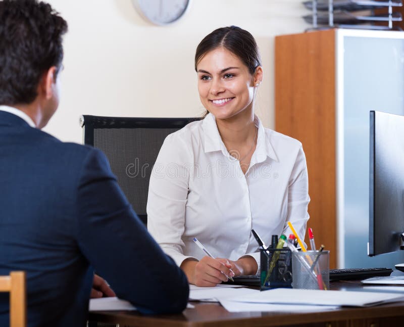 Agente Che Ascolta Il Cliente E Che Sorride Nell'agenzia Immagine Stock ...