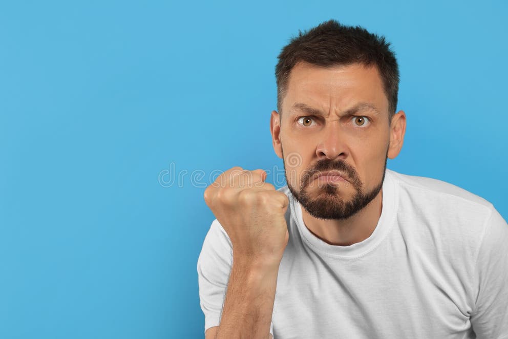 Aggressive Man on Light Blue Background, Space for Text Stock Photo ...