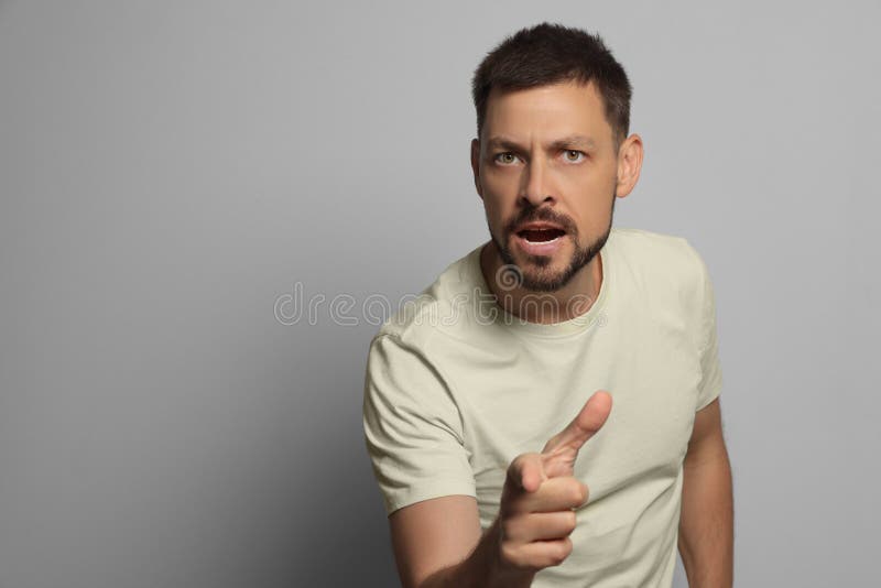 Aggressive Man Pointing on Grey Background, Space for Text Stock Image ...