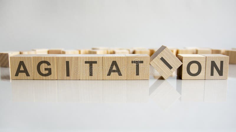 Agitate Text on a Wooden Blocks, Gray Background. Stock Photo - Image ...