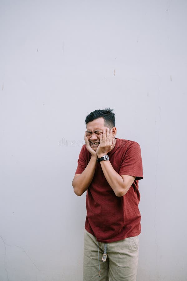 Agonizing Expression of an Asian Man Clutching His Face with Pain Stock ...