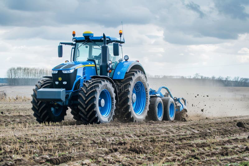 An Agricultural Tractor Driving in the Field Stock Photo - Image of ...