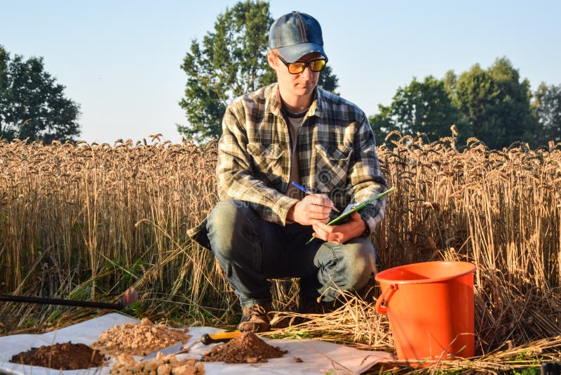 Agriculturist Taking Notes in Soil Sampling Information Sheet at Field ...