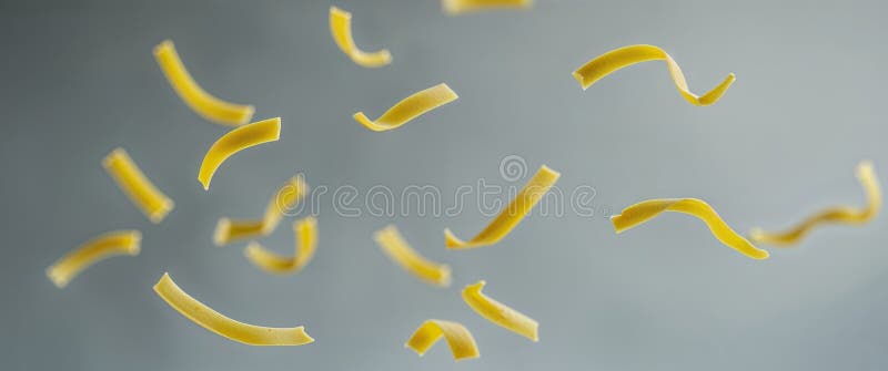 Floating Yellow Pasta Strips with Motion and Texture on Gray Background ...