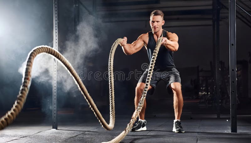 Young Man Doing Hard Exercise Workout in Gym Interior with Rope Waving ...