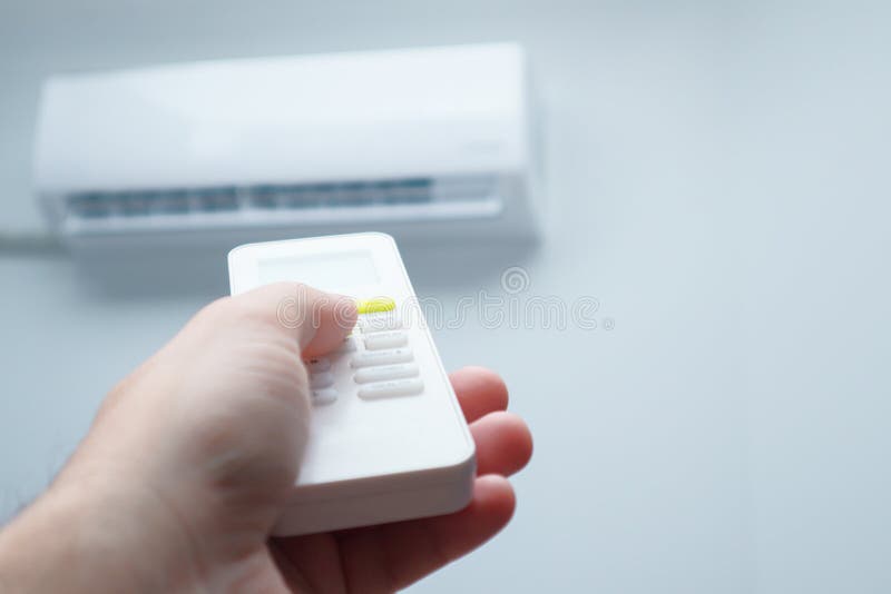 Air Conditioner Inside the Room with Man Operating Remote Controller ...