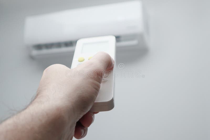 Air Conditioner Inside the Room with Man Operating Remote Controller ...