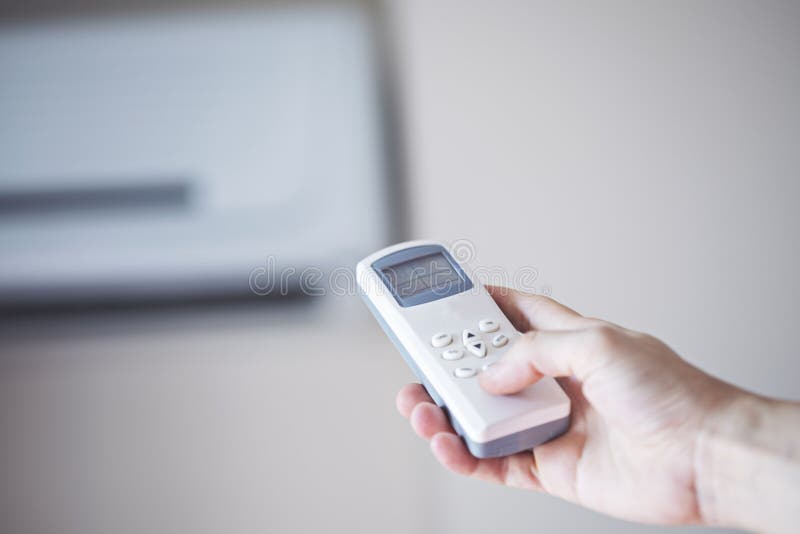 Air Conditioner Inside the Room with Woman Operating Remote Controller ...