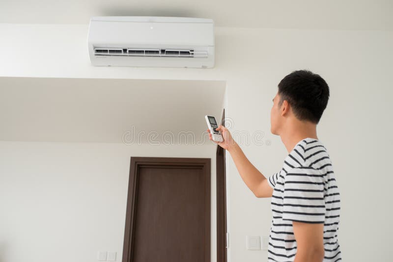 Air Conditioner Inside Unit with Man Operating Remote Controller. / Air ...