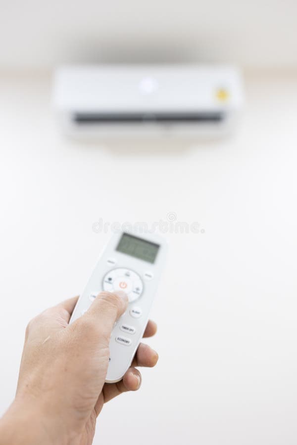 Air Conditioner with Remote Controller. Hand of a Man Adjusting ...