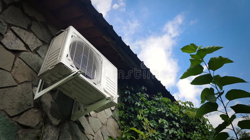 Air Conditioner Unit on a Stone Wall of the Facade of a House Outside ...