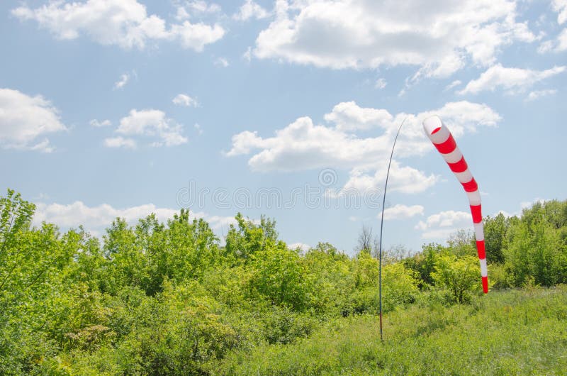 Air Field Direction Sign and a Wind Force Windsock Against the Blue Sky ...