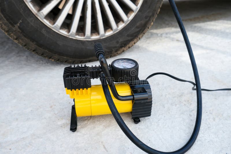 Air Pump Inflating a Wheel of a Broken Car, Car Breakdown Concept Stock ...