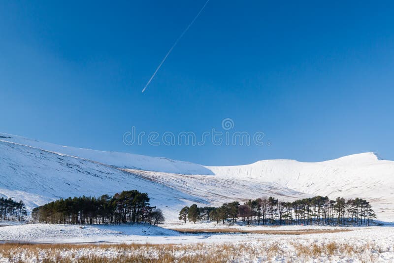 Aircraft Contrail in a Blue Sky Over a Snow Covered Mountain Scene ...