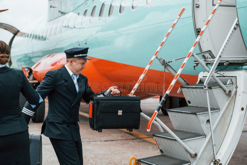 Aircraft Crew in Work Uniform is Together Outdoors Near Plane Stock ...
