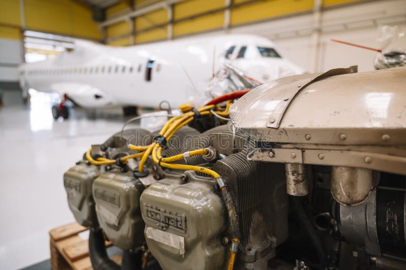 An Aircraft Engine is Shown in a Hangar with a White Aircraft in the ...